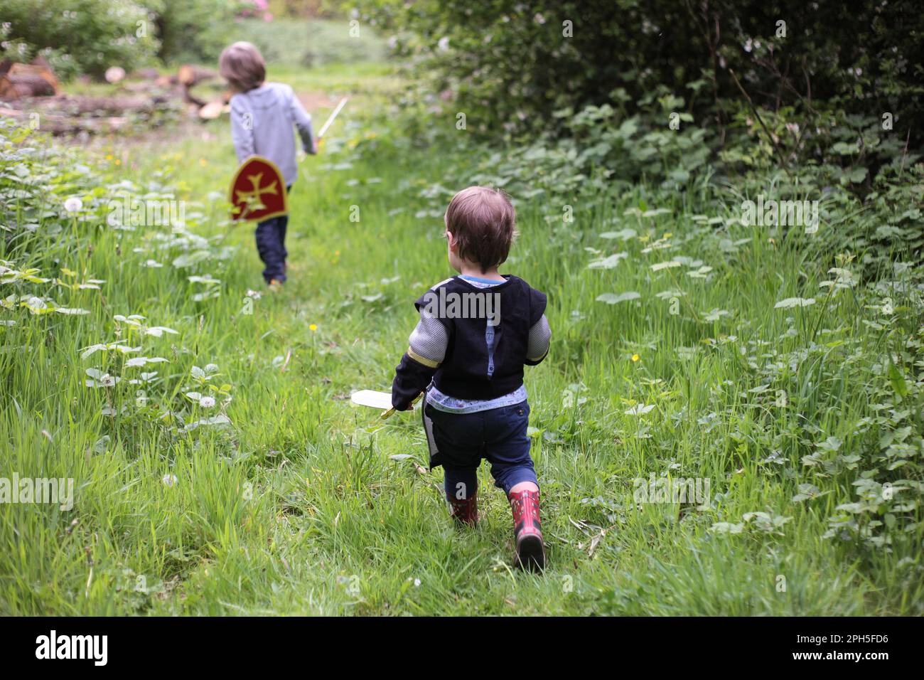 Two children walking through a meadow Stock Photo - Alamy