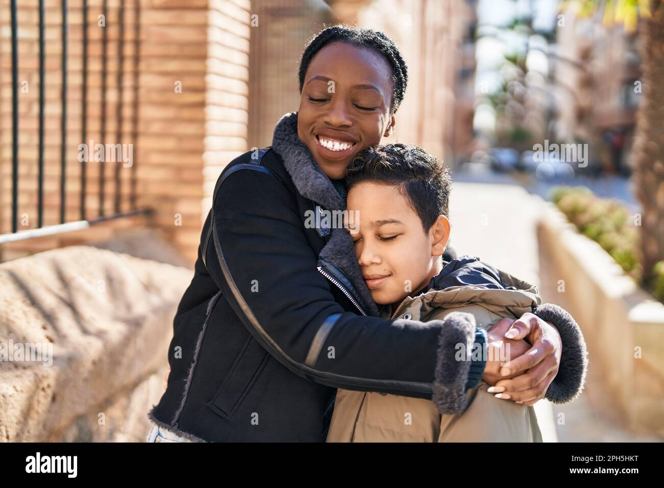 African american mother and son smiling confident hugging each other at street Stock Photo - Alamy