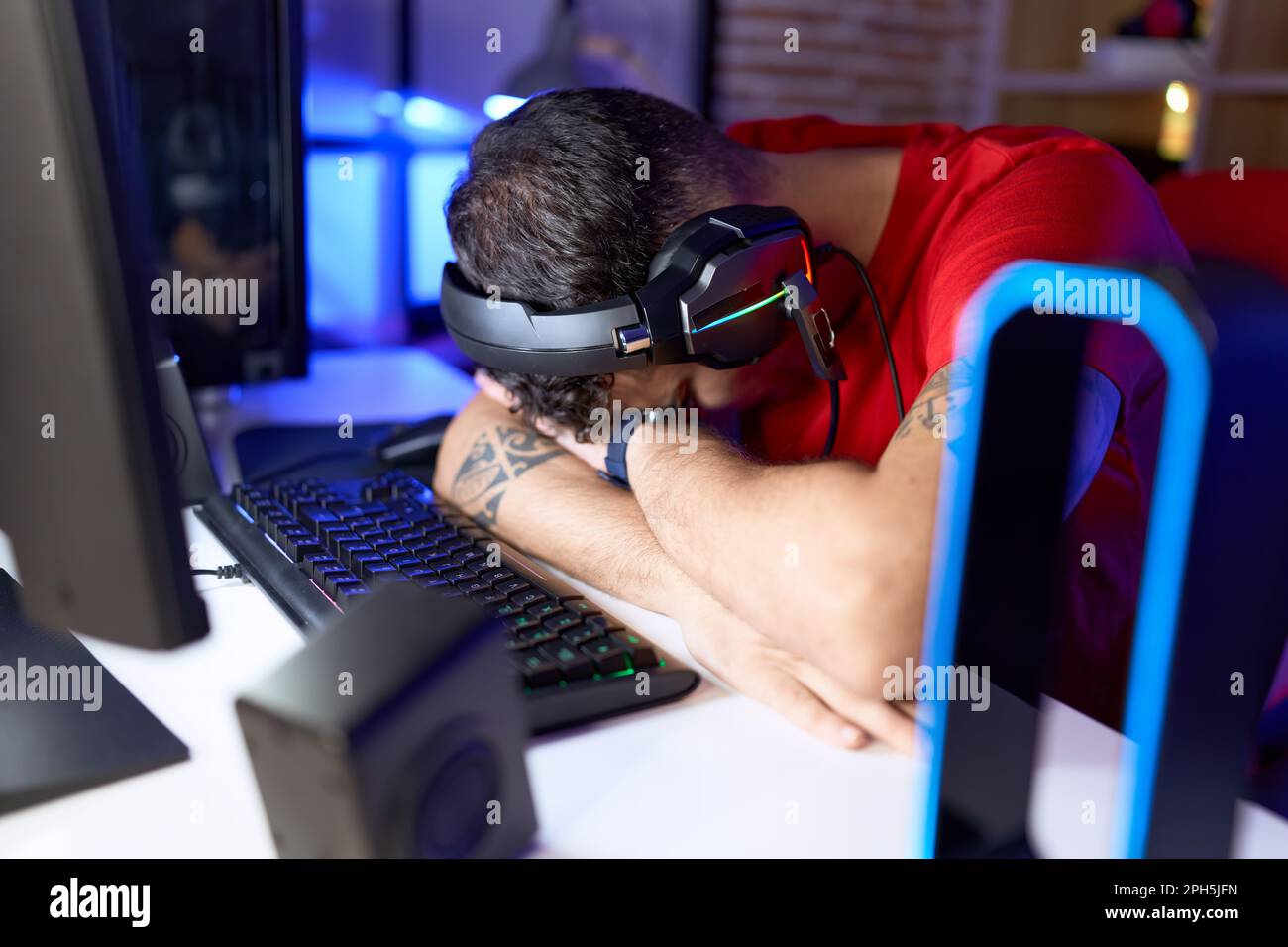 Young hispanic man streamer stressed using computer at gaming room ...