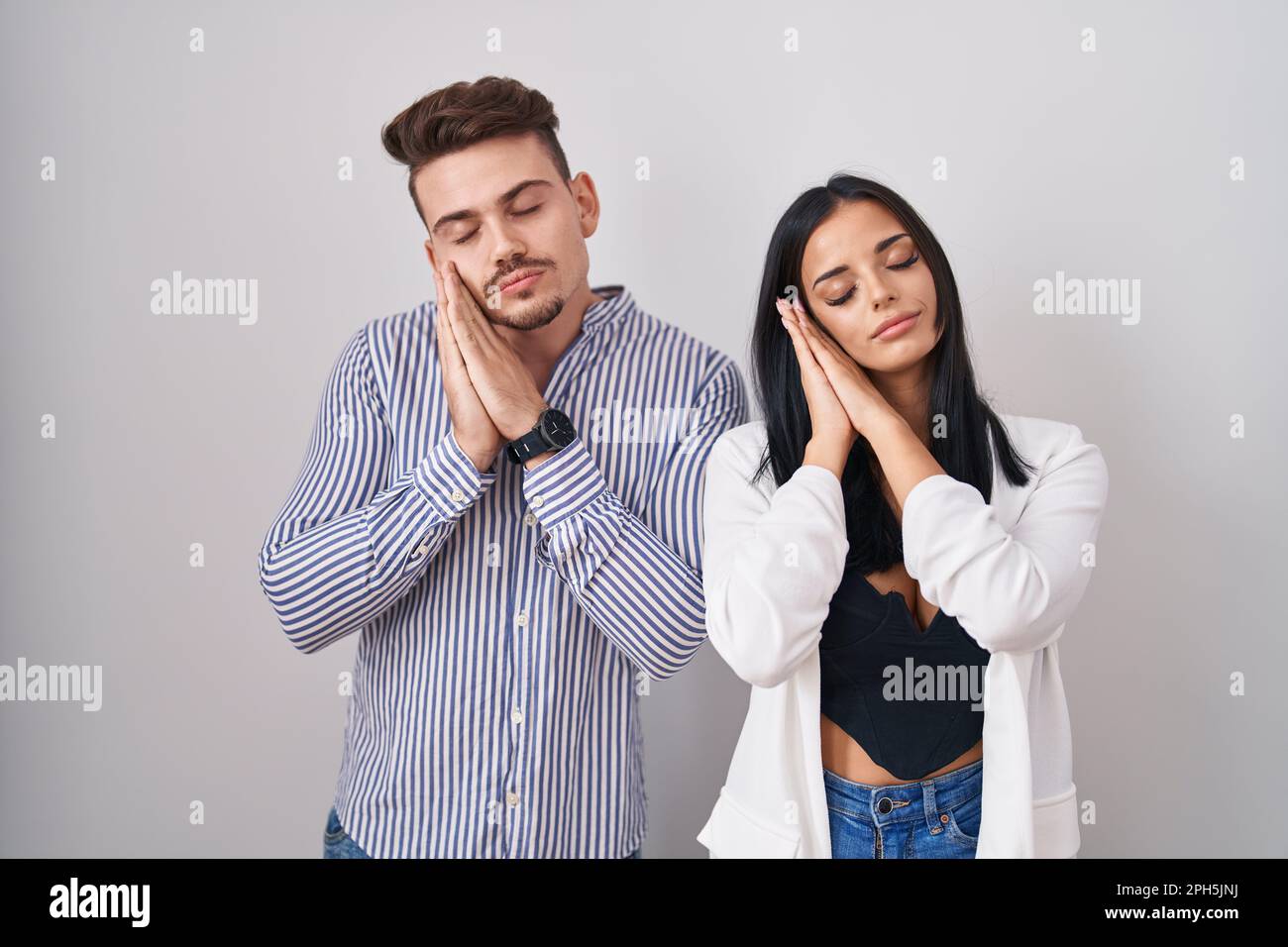 Young hispanic couple standing over white background sleeping tired ...