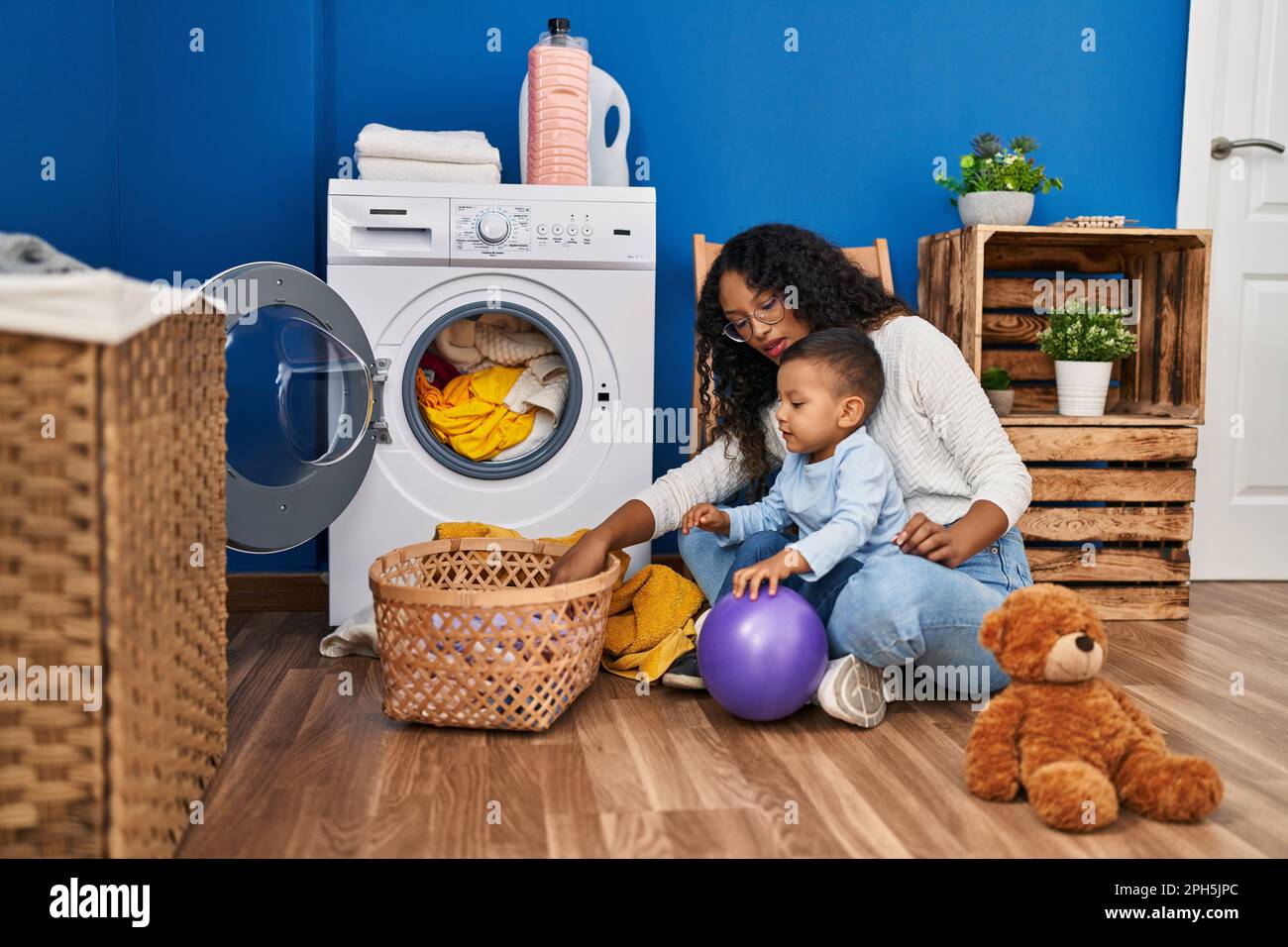 Mother and son smiling confident washing clothes at laundry room Stock ...