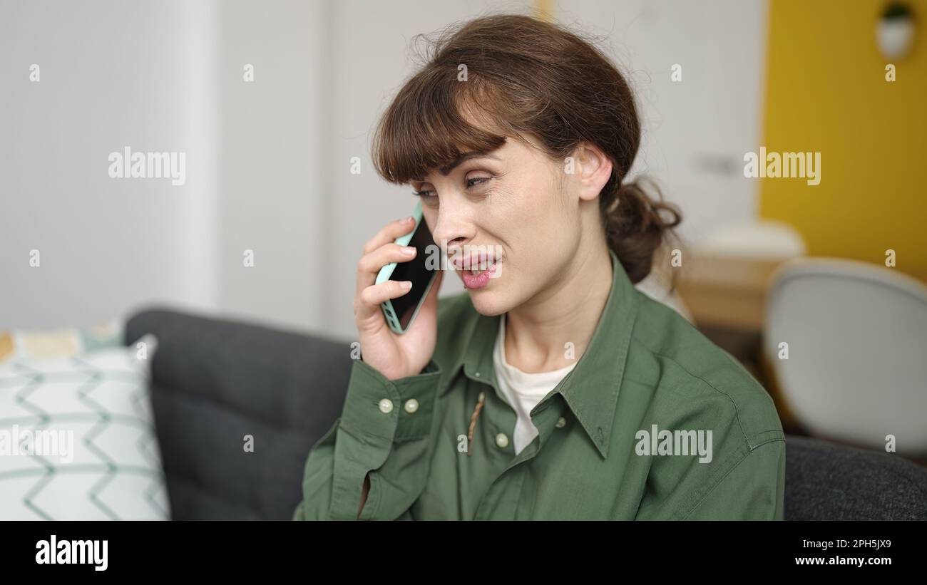 Young caucasian woman talking on the phone with disgust at home Stock ...