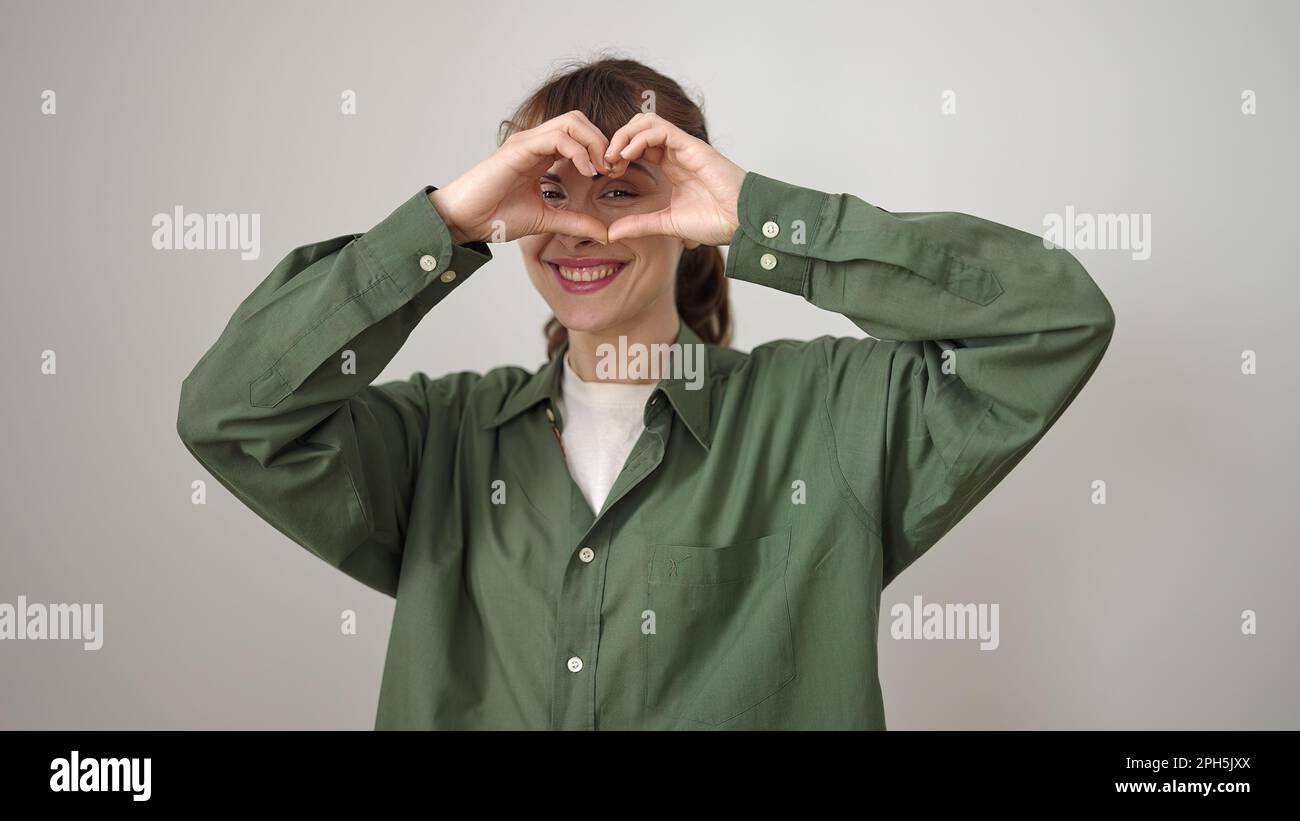 Young caucasian woman doing heart shape with hands over eye over ...