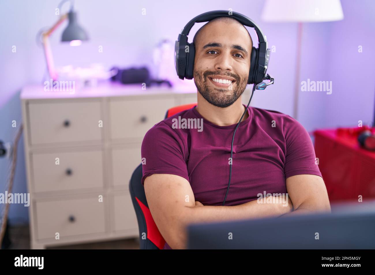 Young latin man streamer smiling confident sitting with arms crossed ...