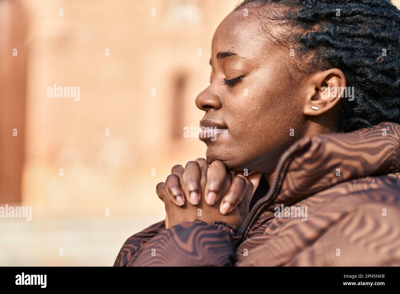 African american woman praying with closed eyes at street Stock Photo - Alamy