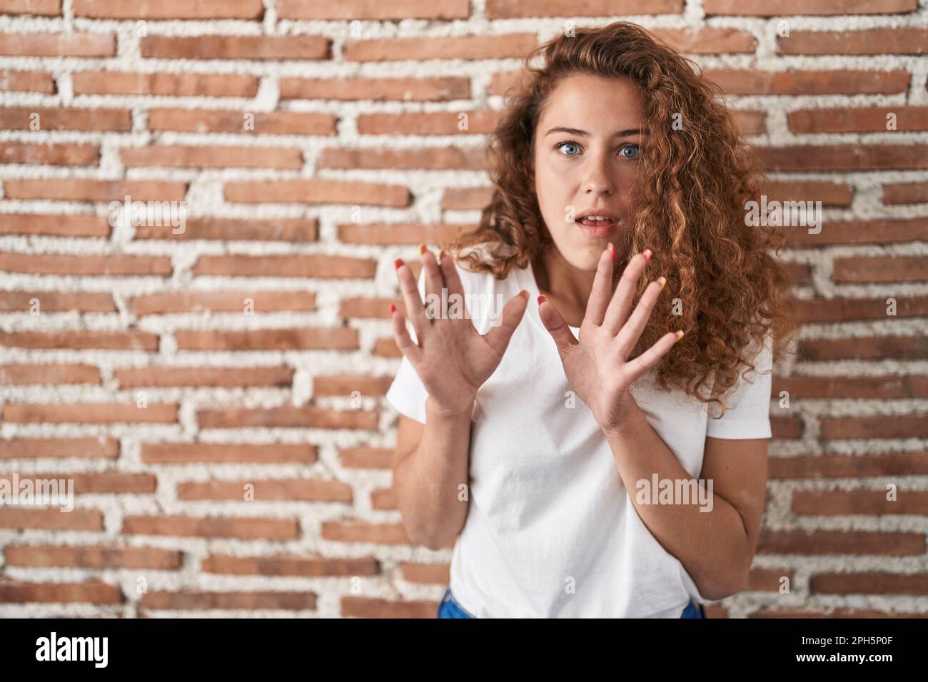 Young Caucasian Woman Standing Over Bricks Wall Background Afraid And