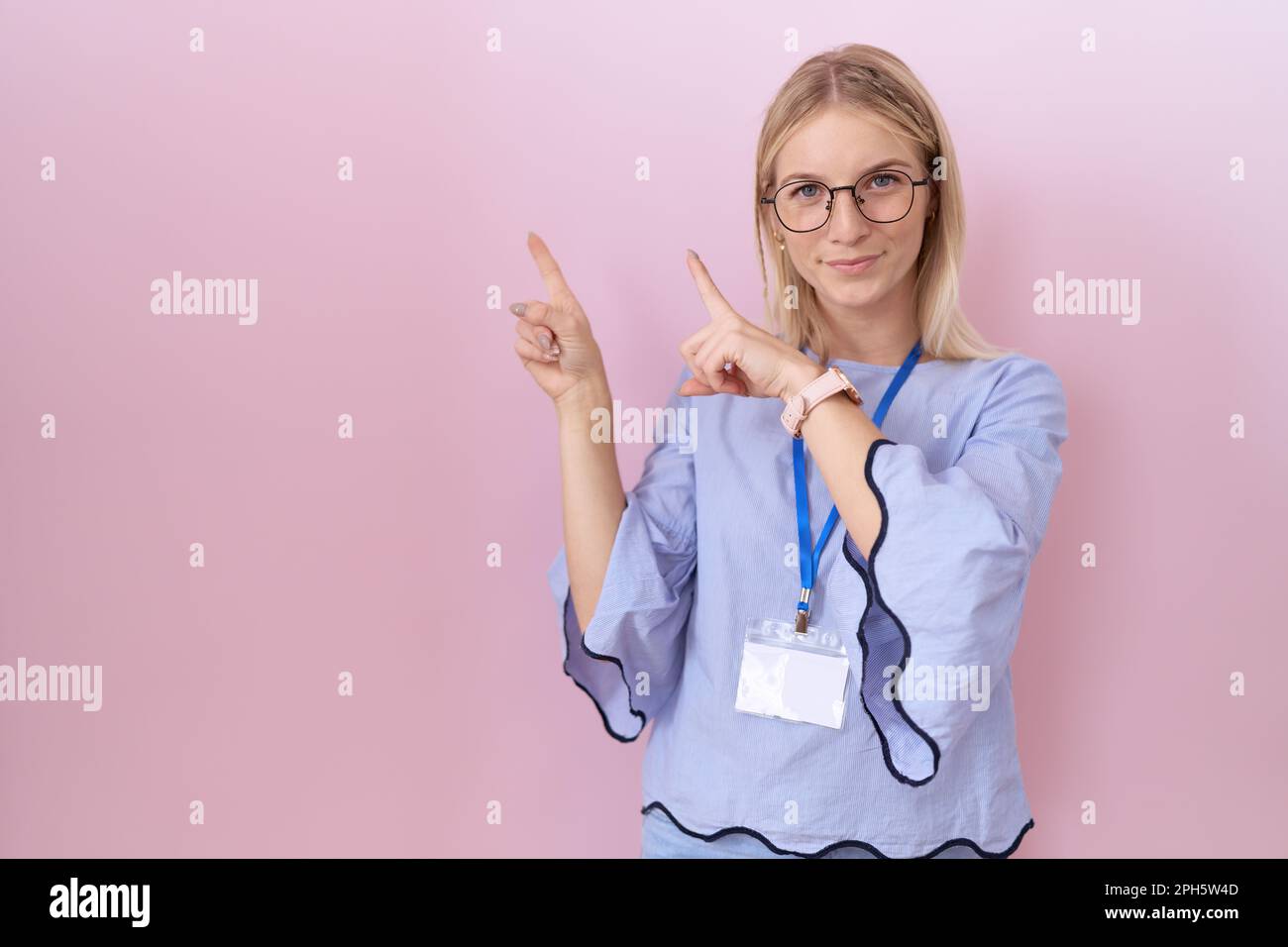 Young caucasian business woman wearing id card smiling and looking at ...