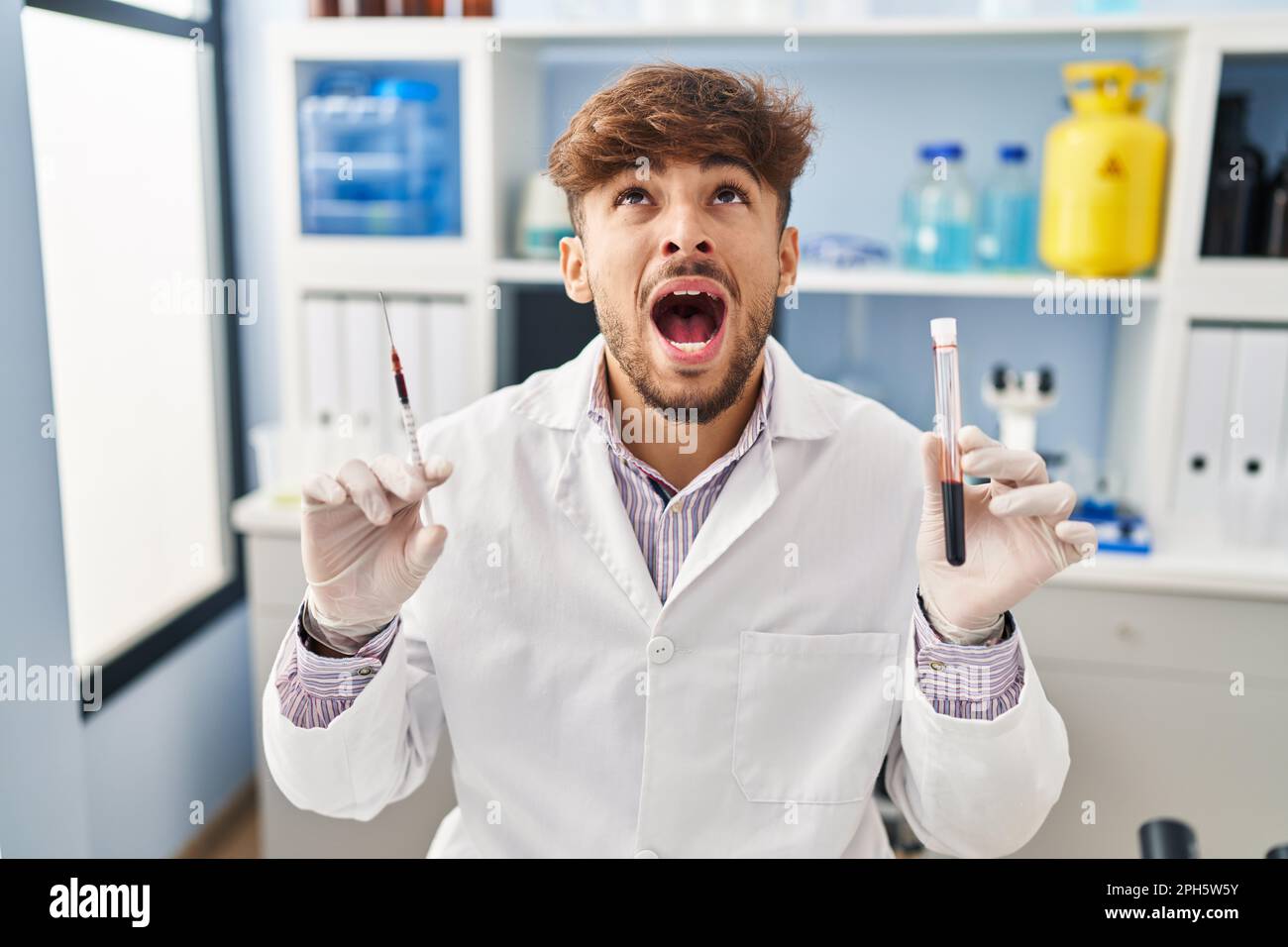 Arab man with beard working at scientist laboratory holding blood ...