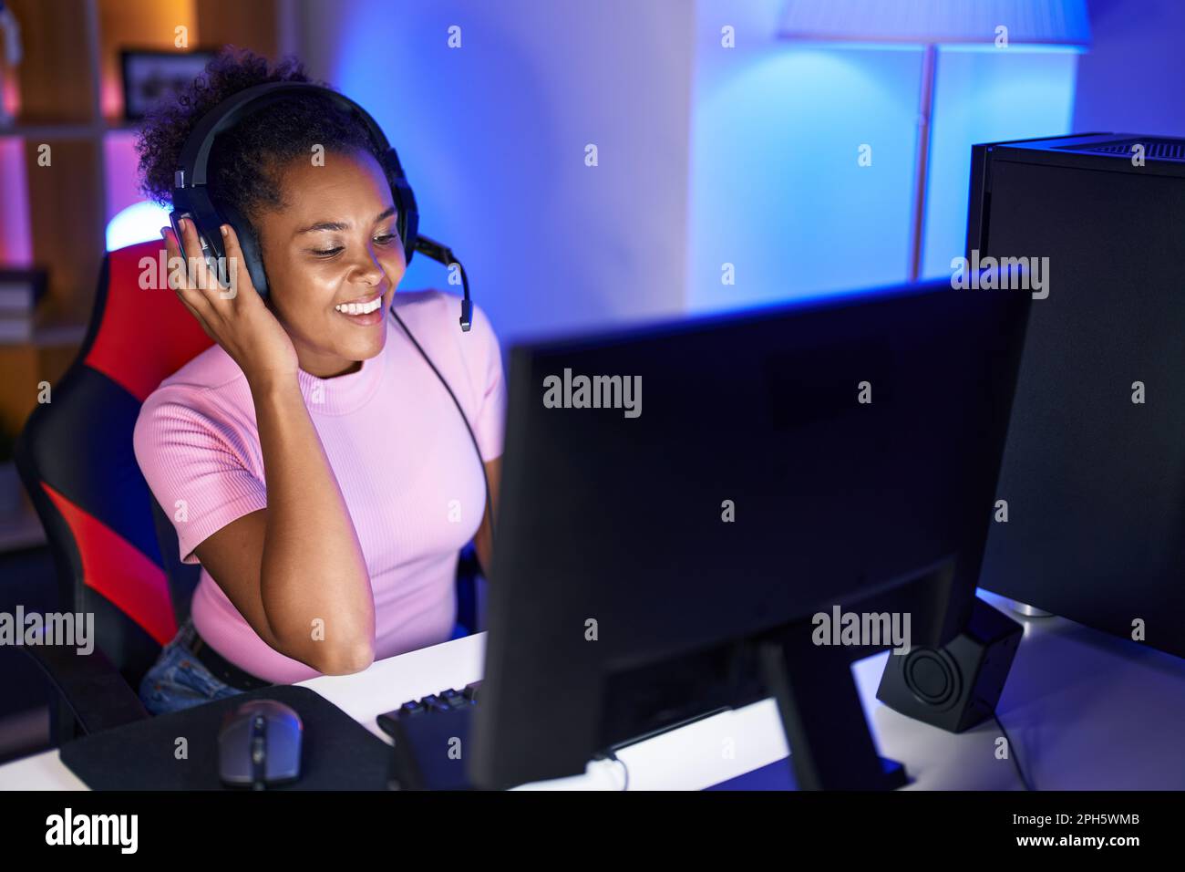 African american woman streamer playing video game using computer at ...