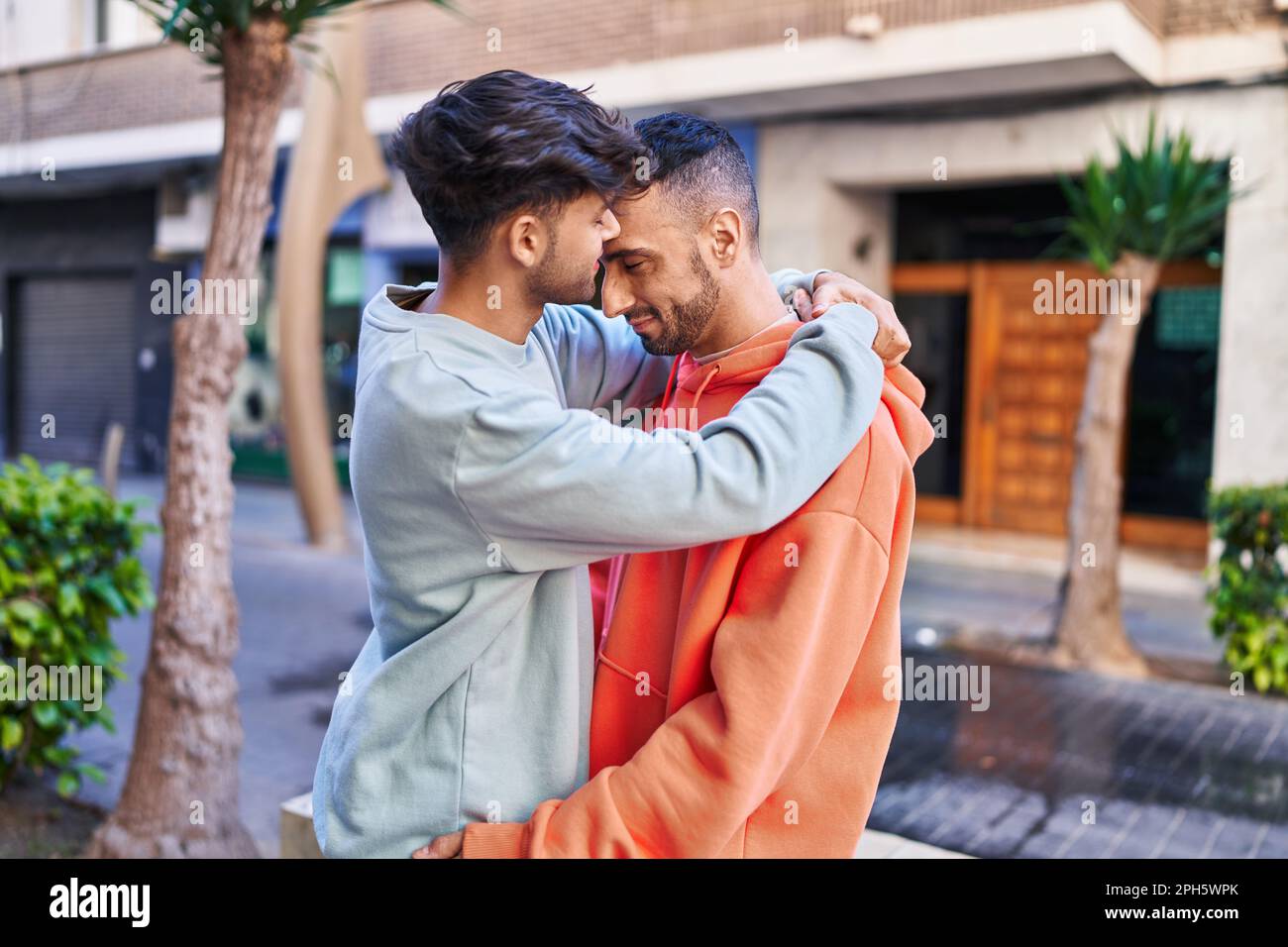 Two man couple hugging each other standing at street Stock Photo - Alamy