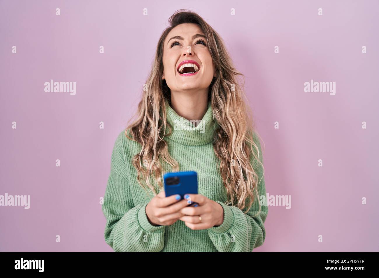 Young caucasian woman using smartphone typing message angry and mad ...