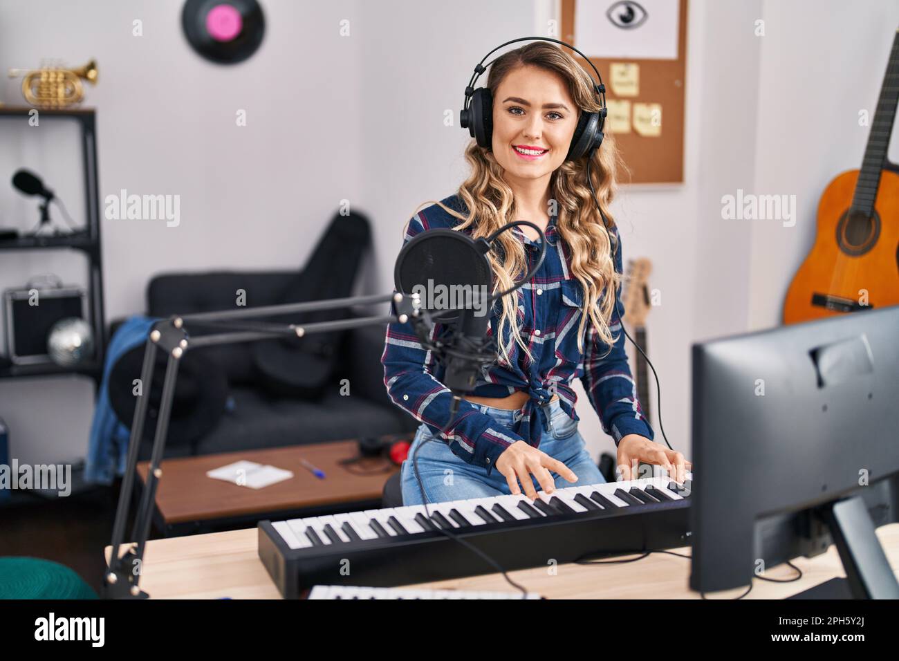 Young woman musician playing piano keyboard at music studio Stock Photo ...