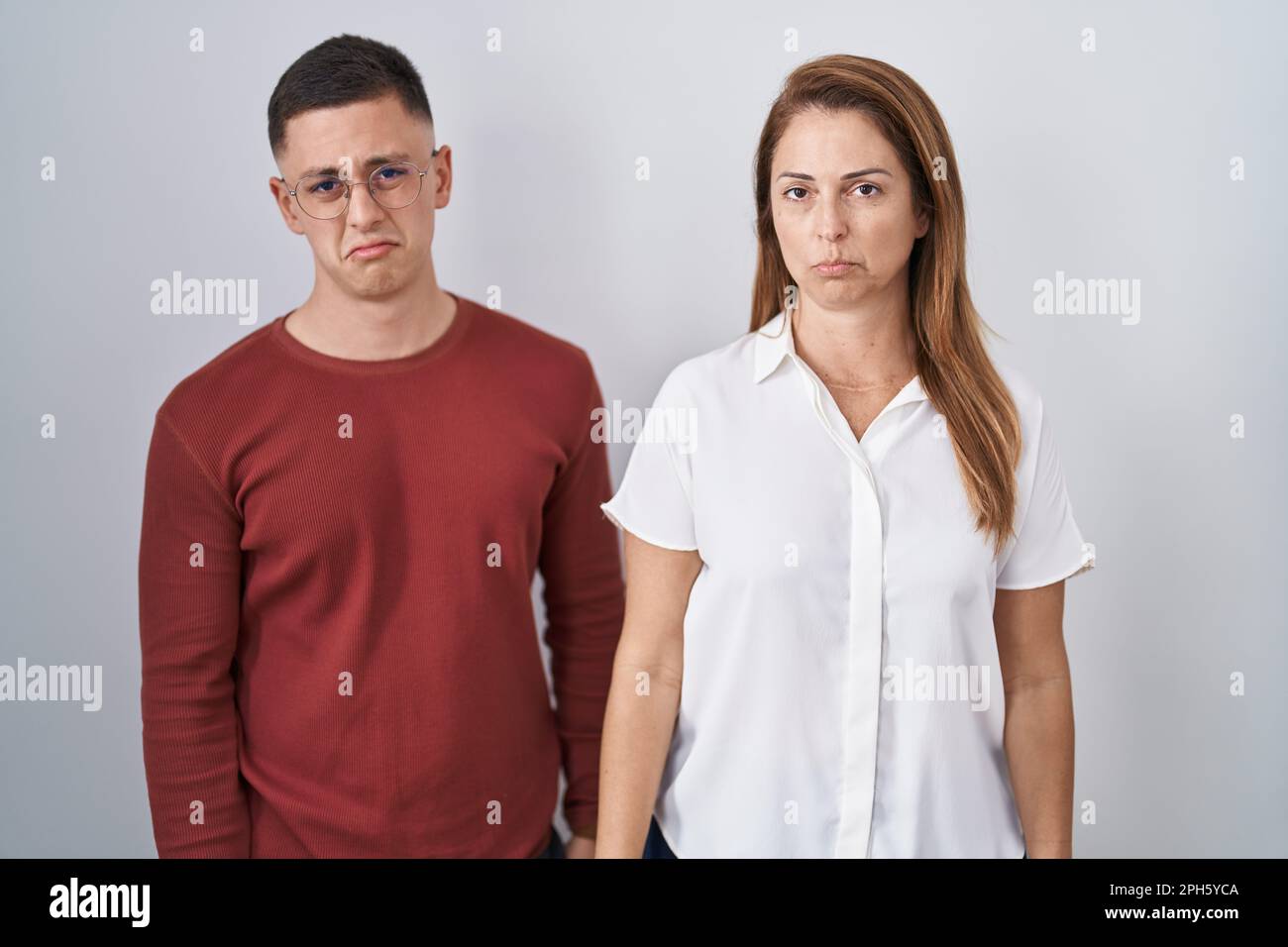 Mother and son standing together over isolated background depressed and ...