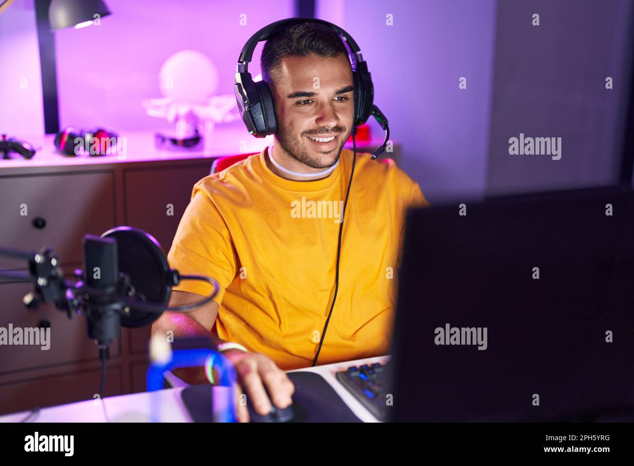 Young hispanic man streamer playing video game using computer at gaming ...