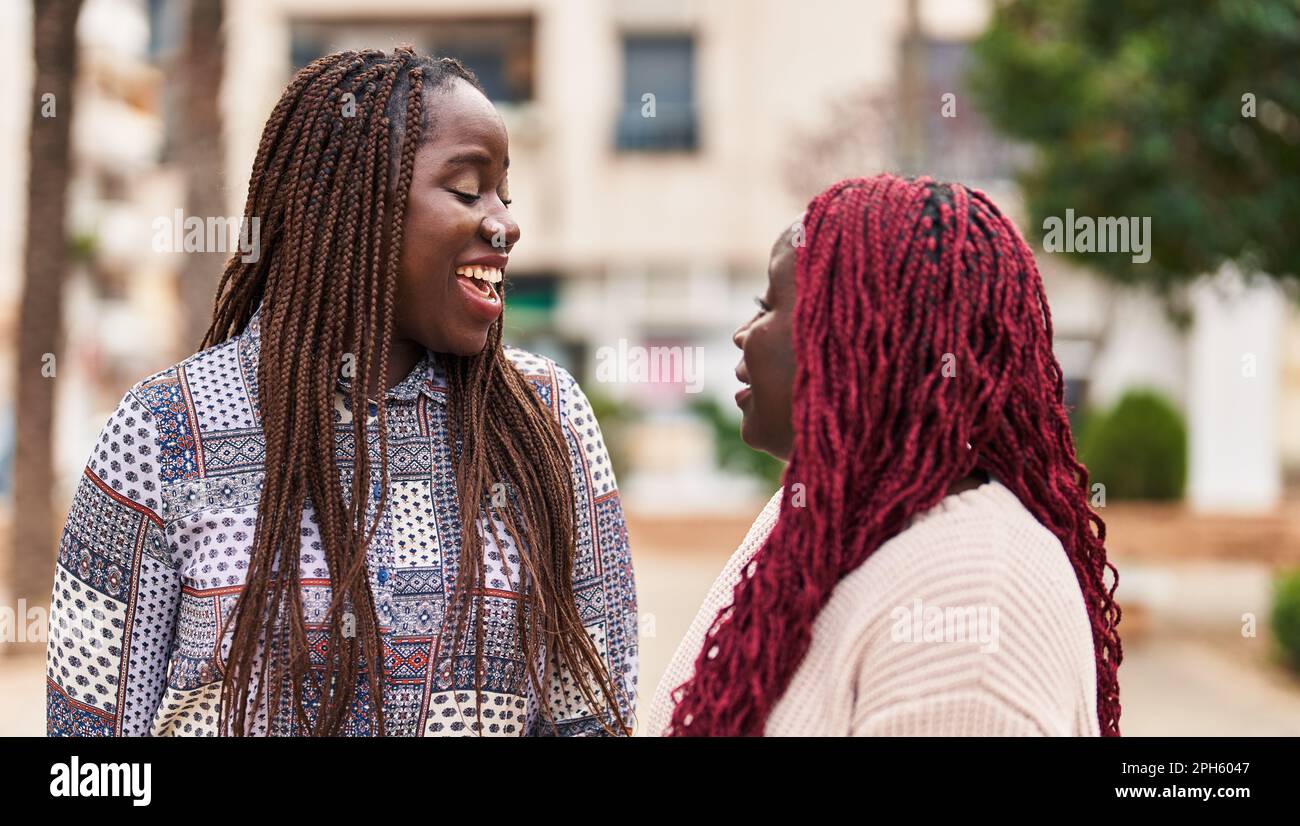 African american women friends standing together speaking at park Stock ...
