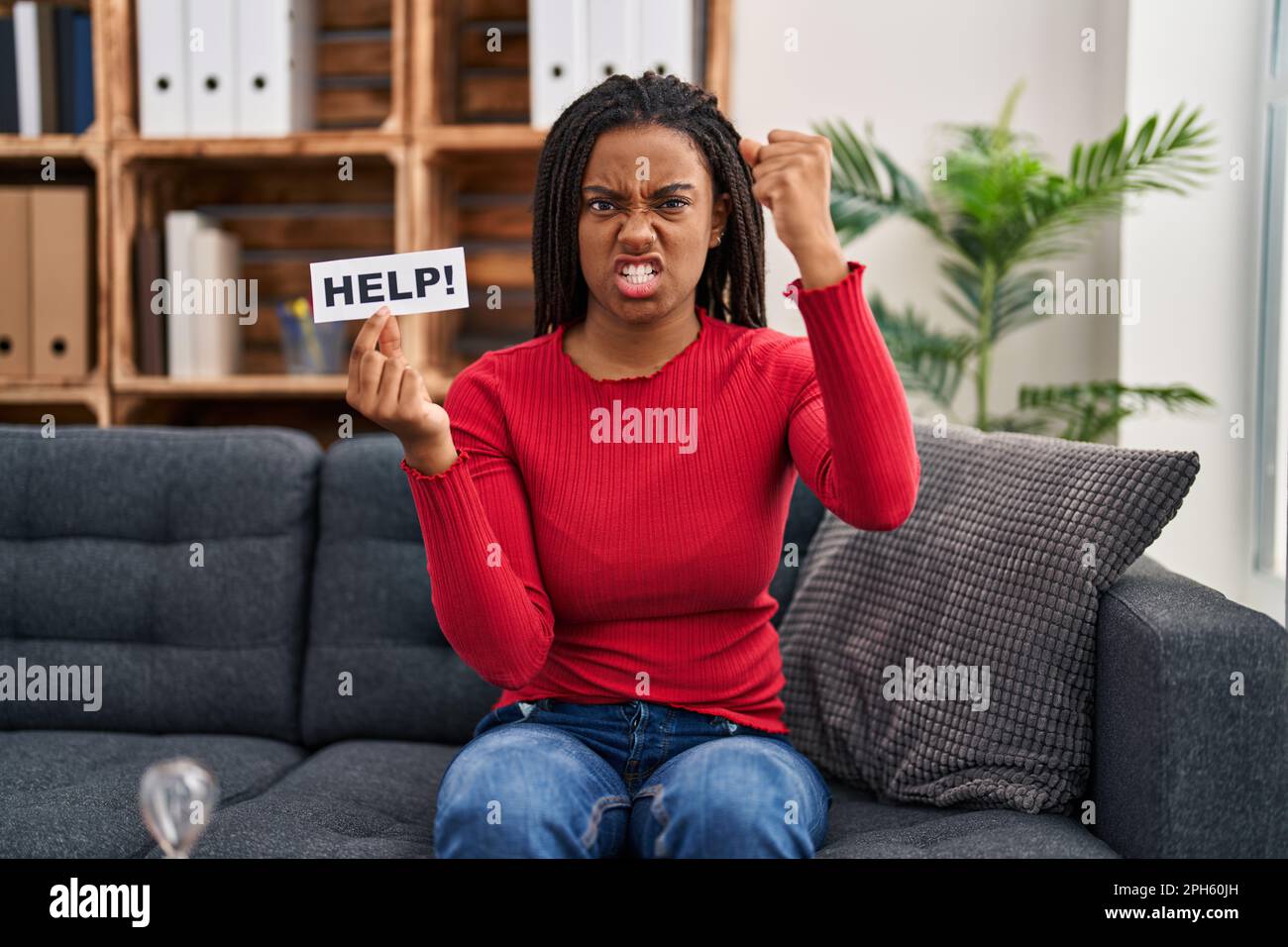 Young african american with braids doing therapy holding help banner ...