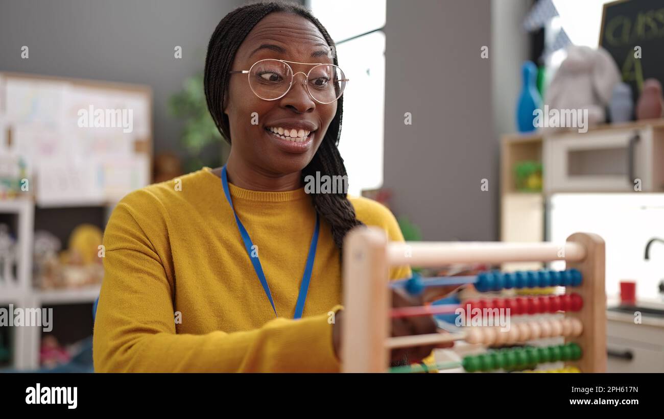 African woman working as teacher teaching maths with abacus at ...