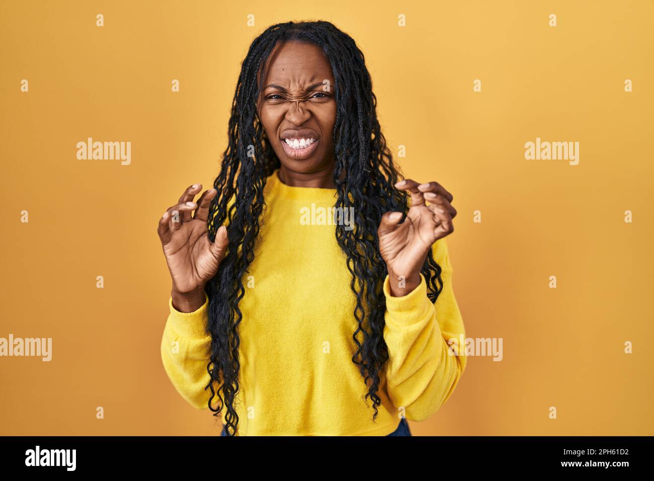 African woman standing over yellow background disgusted expression ...