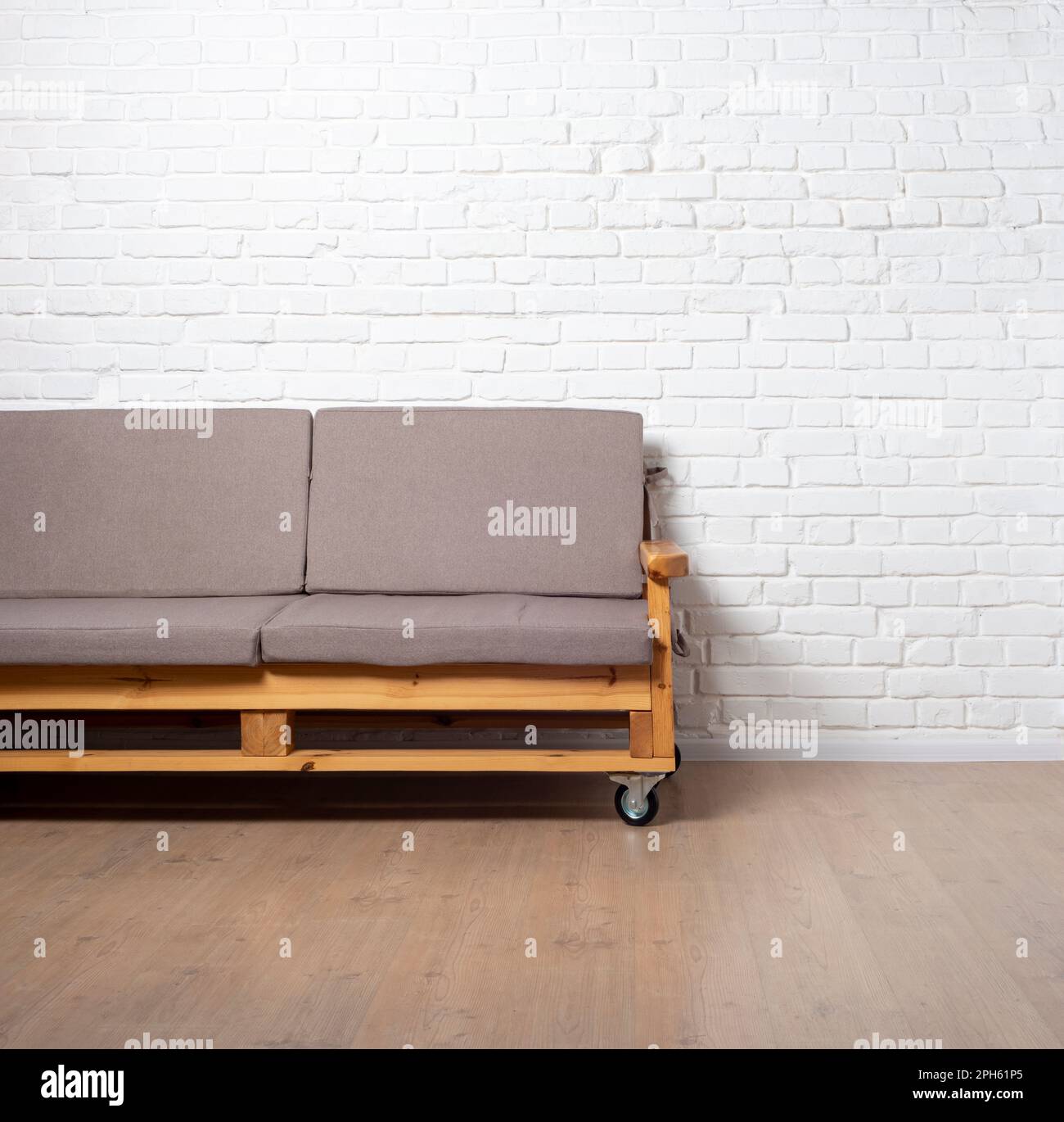 Loft style sofa on white brick wall background Stock Photo - Alamy