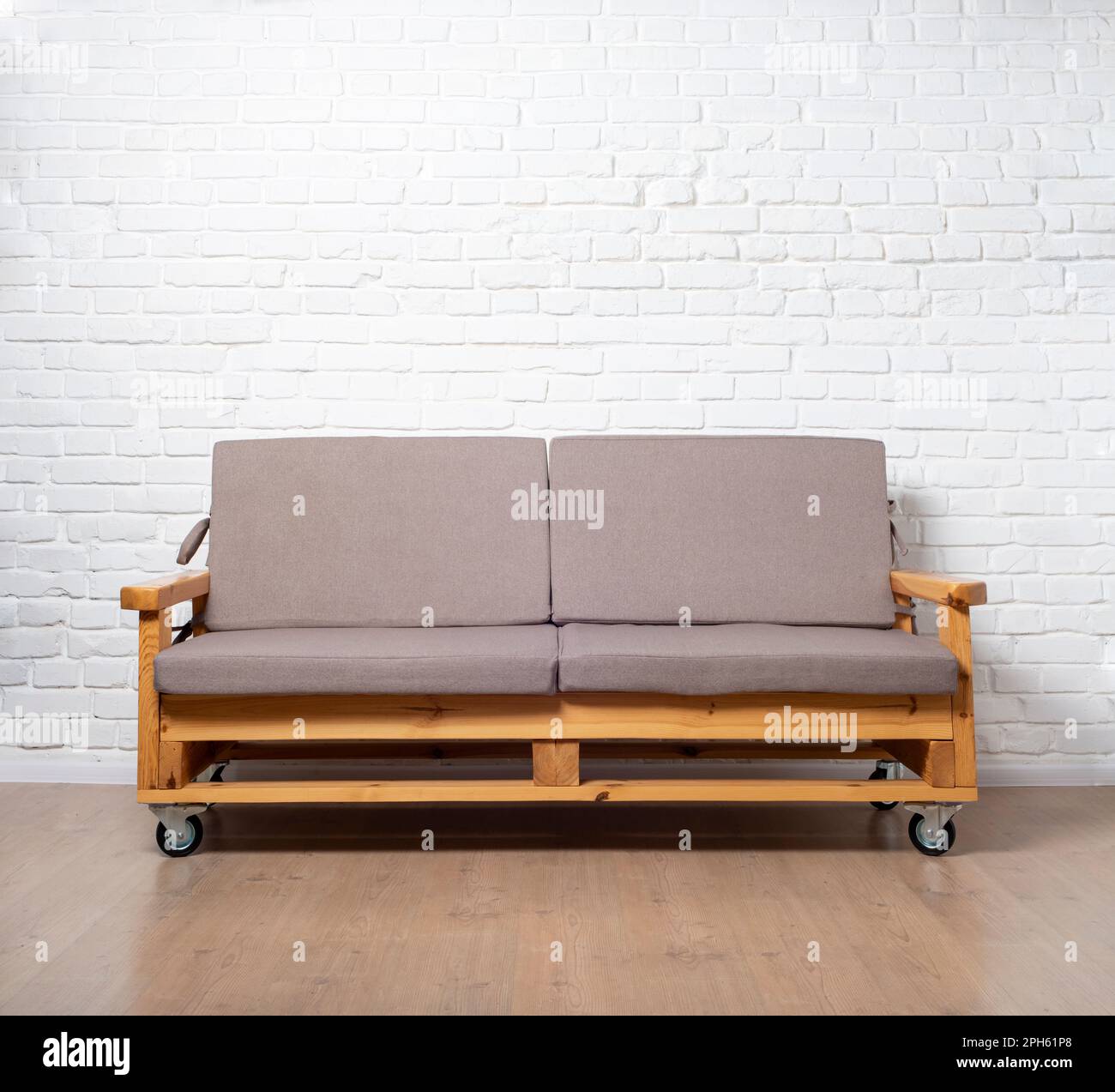 Loft style sofa on white brick wall background Stock Photo - Alamy