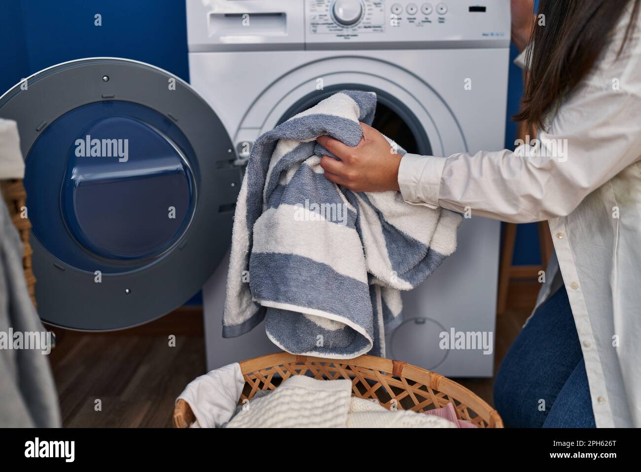 Young hispanic woman washing clothes at laundry room Stock Photo - Alamy