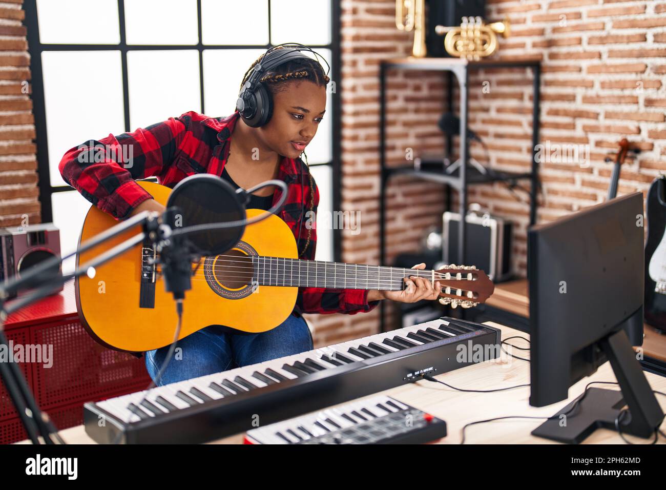 African american woman musician playing classical guitar at music ...