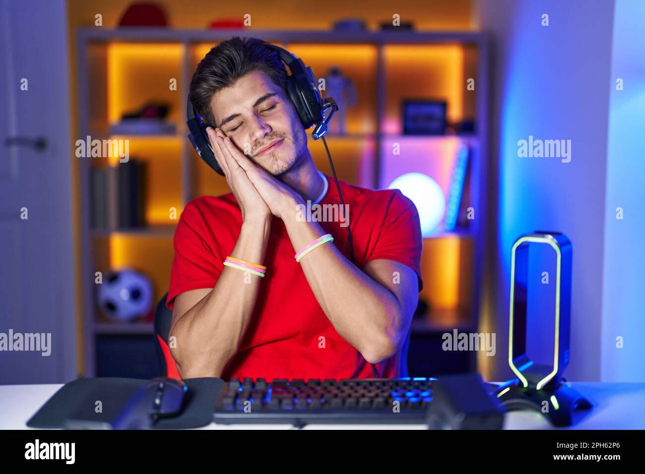 Young hispanic man playing video games sleeping tired dreaming and ...