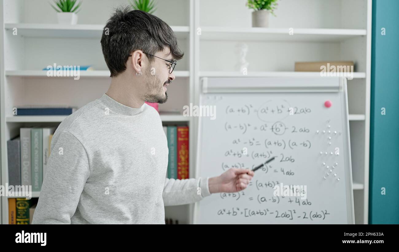 Young hispanic man teacher teaching maths lesson at university ...