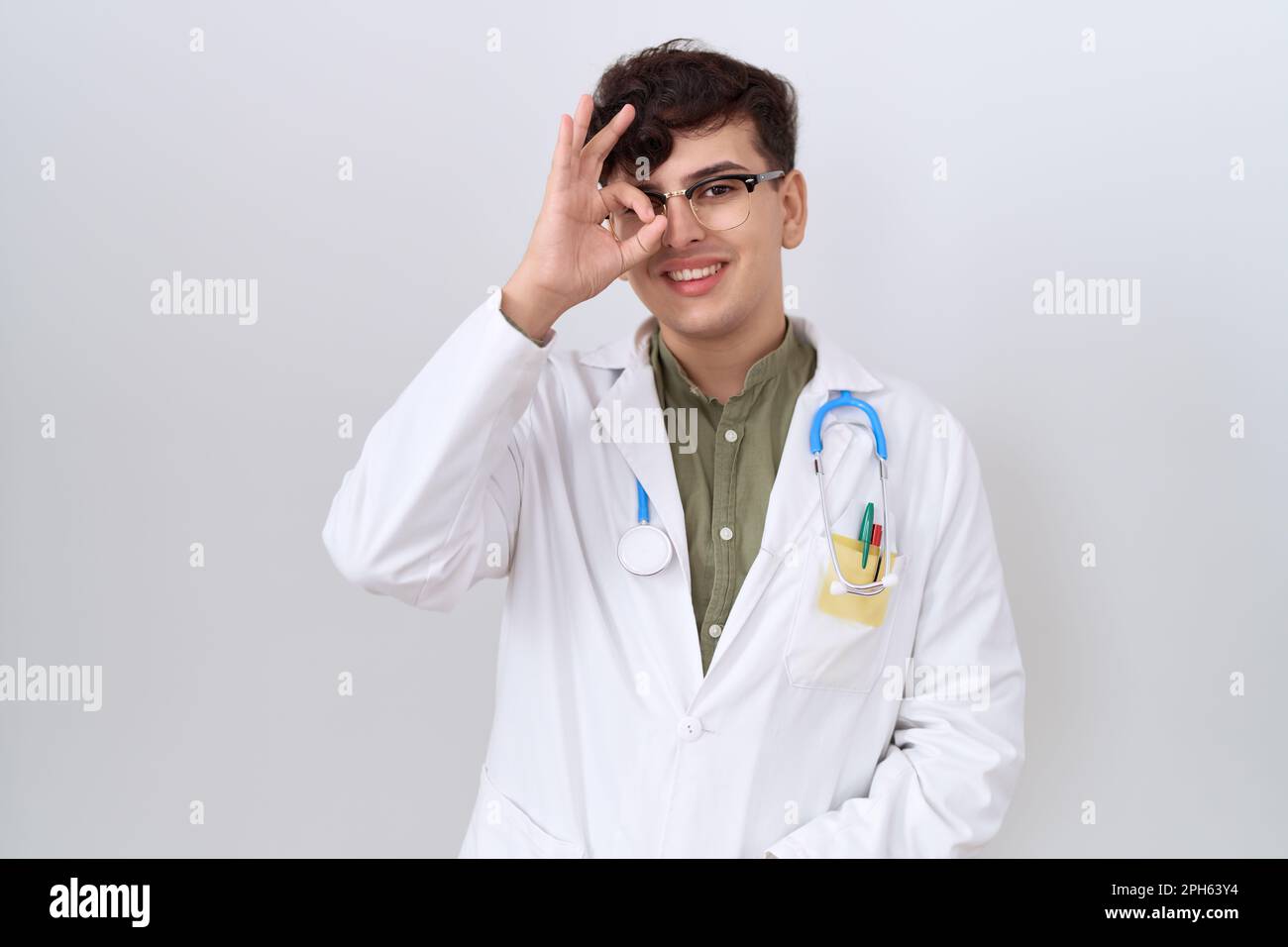 Young non binary man wearing doctor uniform and stethoscope doing ok ...