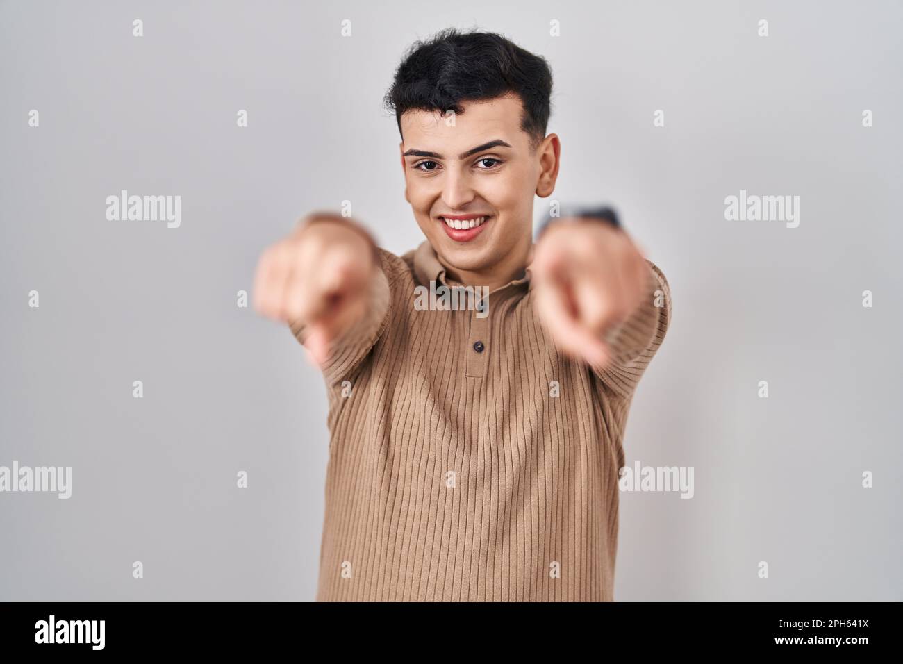 Non binary person standing over isolated background pointing to you and ...