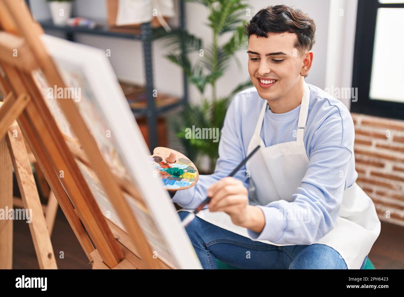 Young non binary man artist smiling confident drawing at art studio ...
