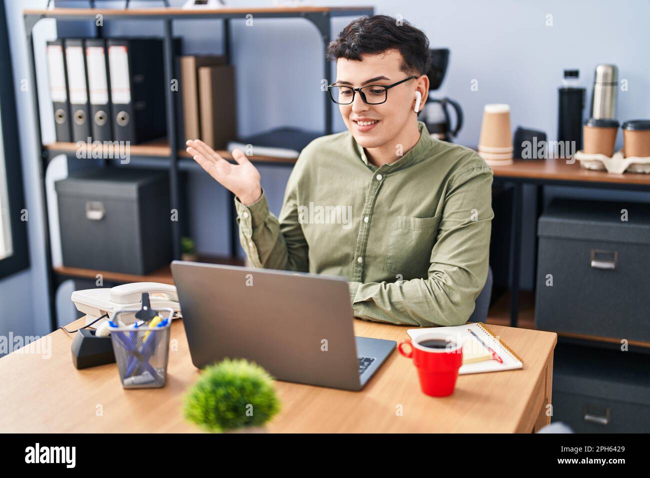 Non binary person working at the office wearing glasses celebrating ...
