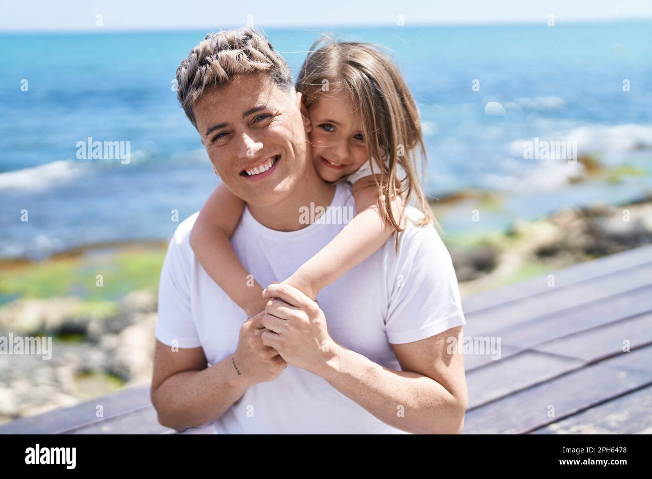 Father and daughter smiling confident hugging each other at seaside Stock Photo - Alamy