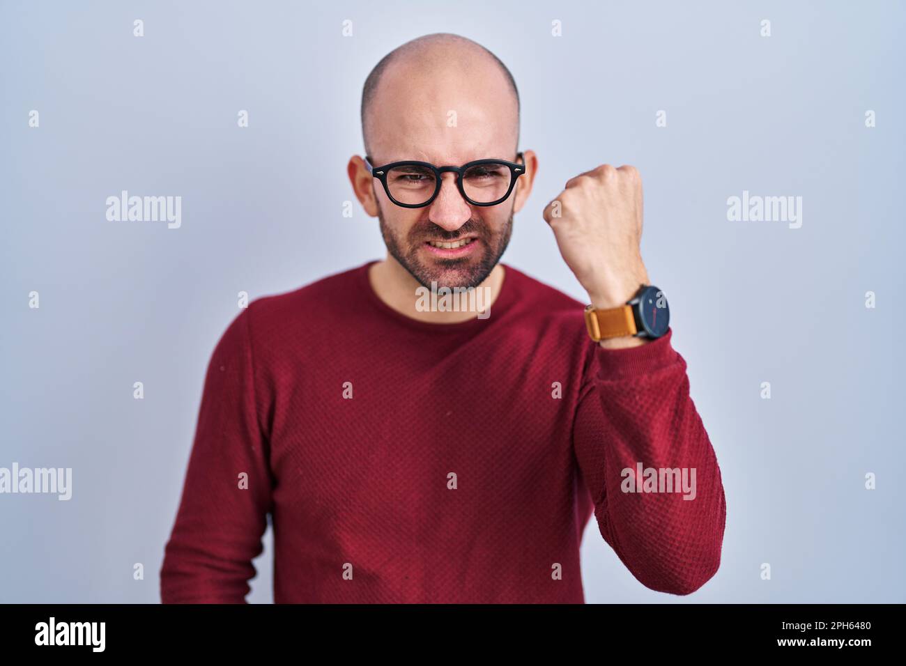 Young bald man with beard standing over white background wearing ...