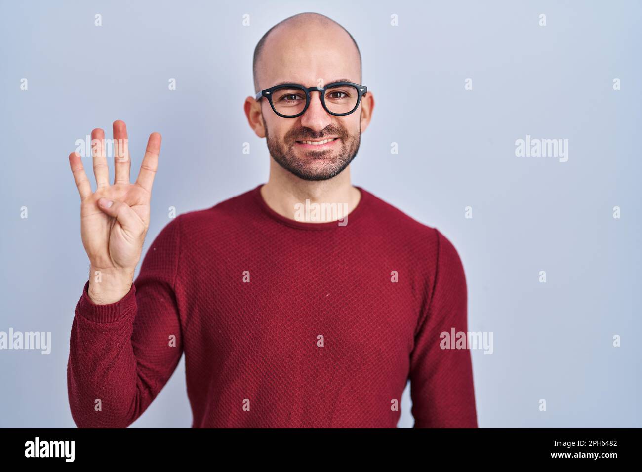 Young bald man with beard standing over white background wearing ...