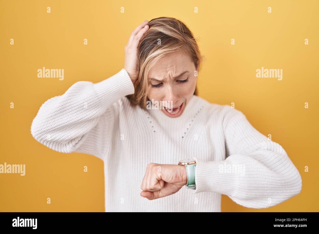 Young caucasian woman wearing white sweater over yellow background ...