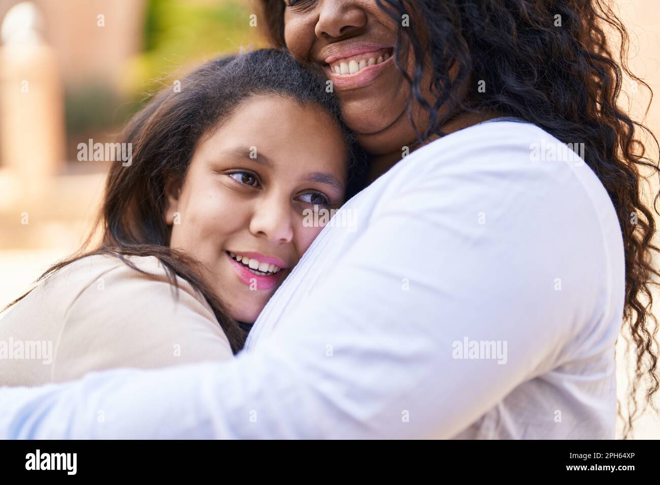 Mother And Daughter Smiling Confident Hugging Each Other At Street