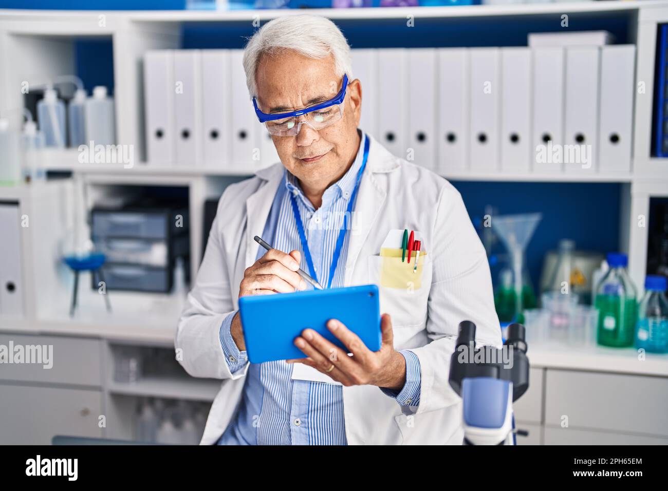 Senior man scientist using touchpad working at laboratory Stock Photo - Alamy