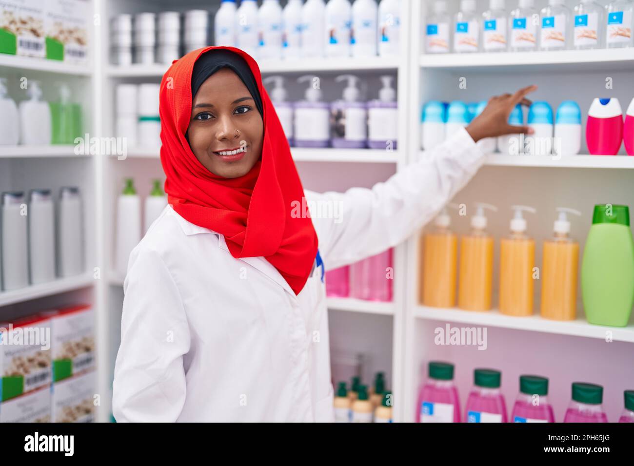 Young beautiful woman pharmacist smiling confident holding medication ...