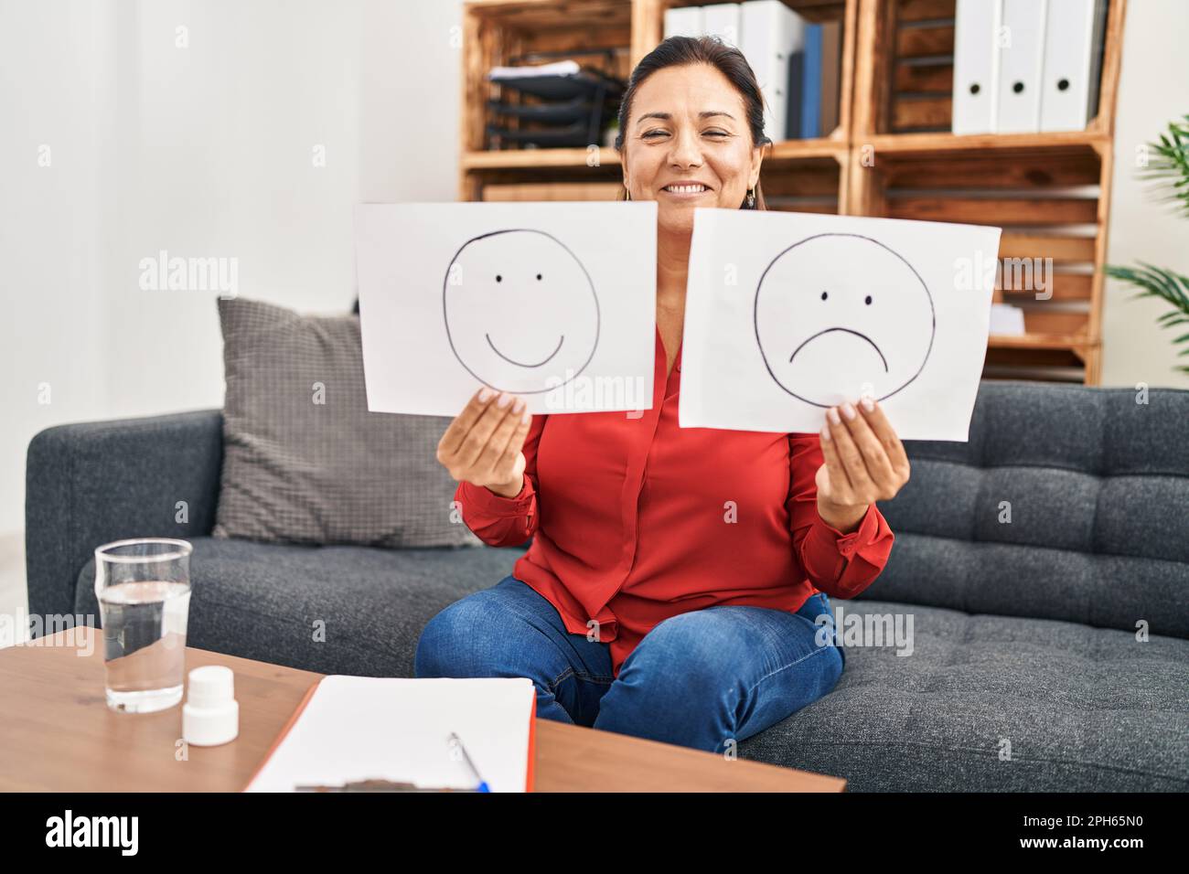 Middle age hispanic woman working on depression holding sad to happy ...
