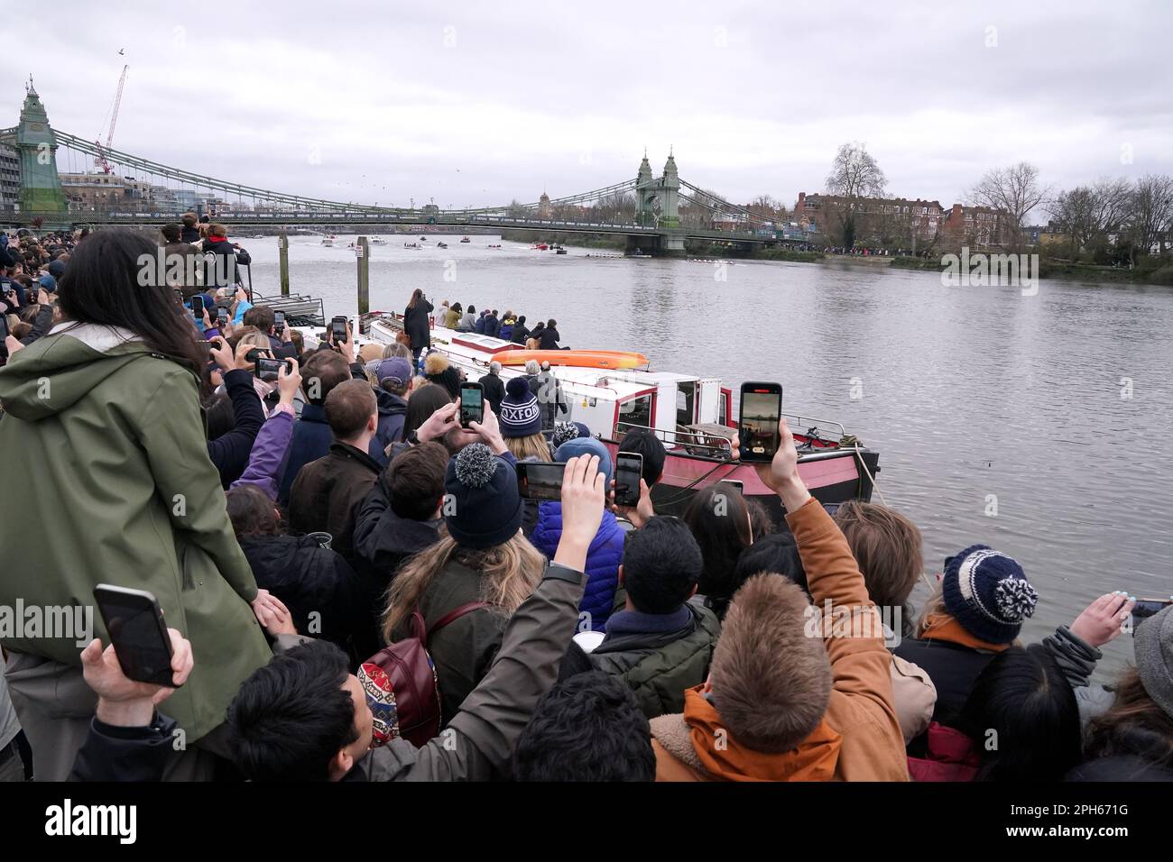 Spectators watch as the Oxford and Cambridge boats in the Women’s race ...