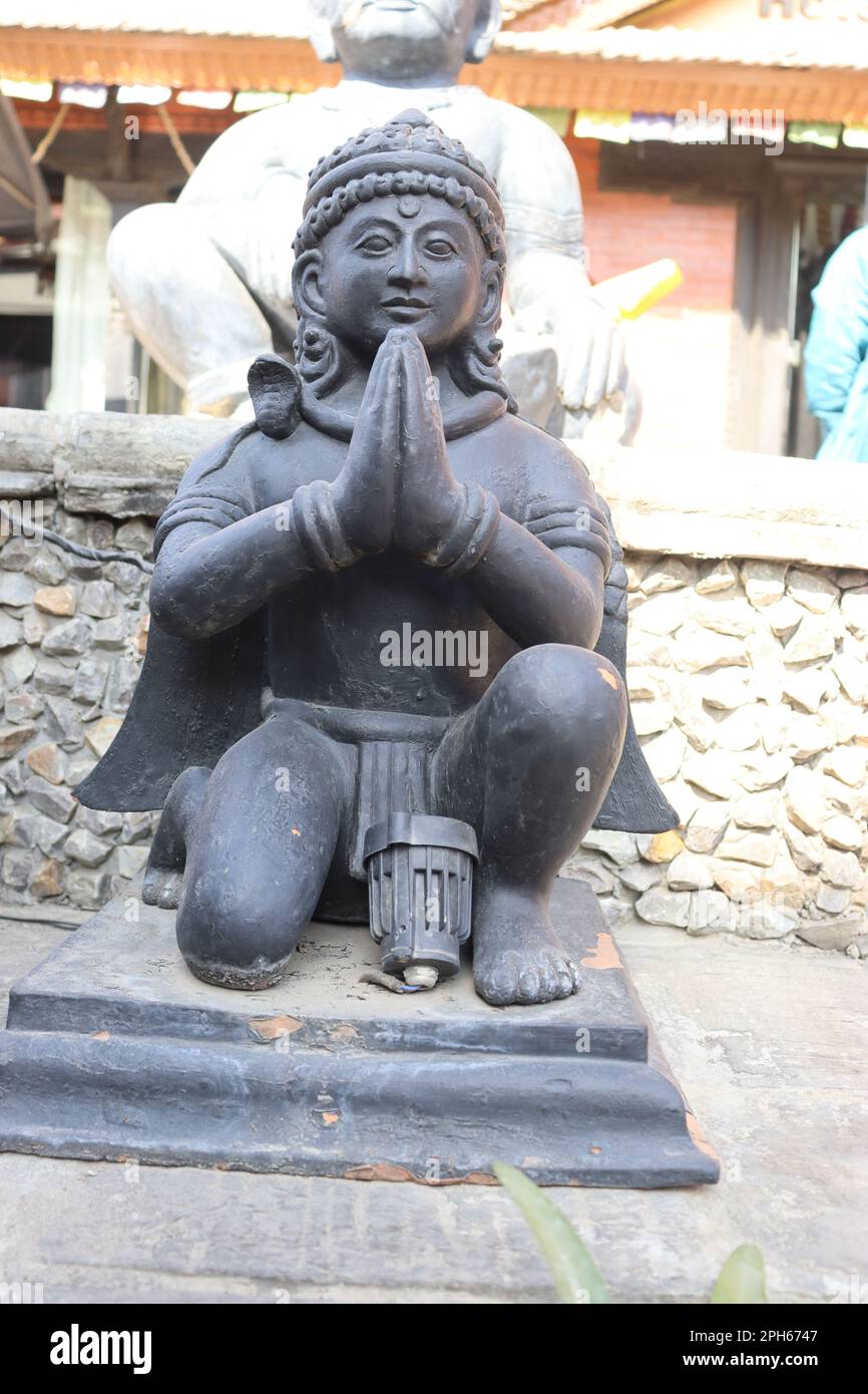 Statue of a god with snake around the neck in a setting position made ...
