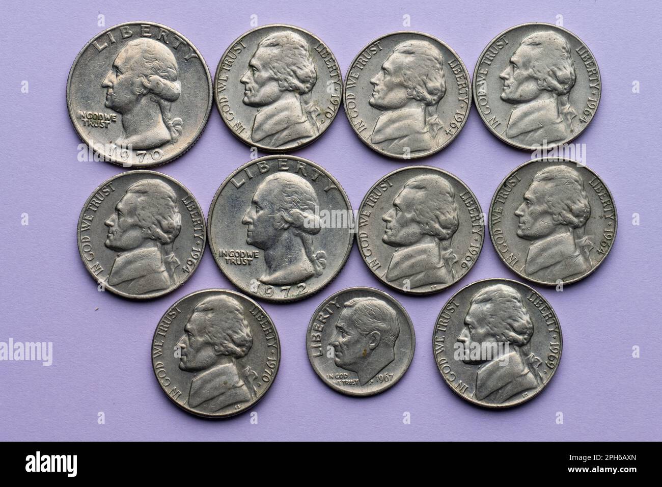 Assortment of old nickel, dime and quarter coins on purple background ...