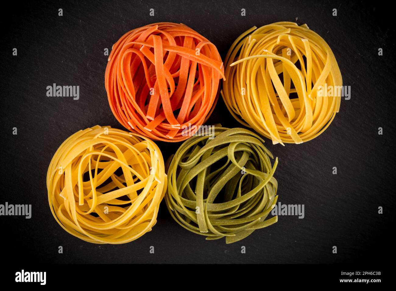 Four colour roll nest pasta on a white background Stock Photo - Alamy