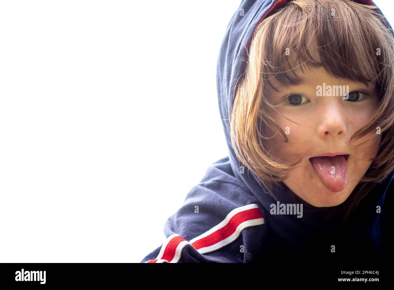 Defiant boy sticks tongue out in hoody Stock Photo - Alamy