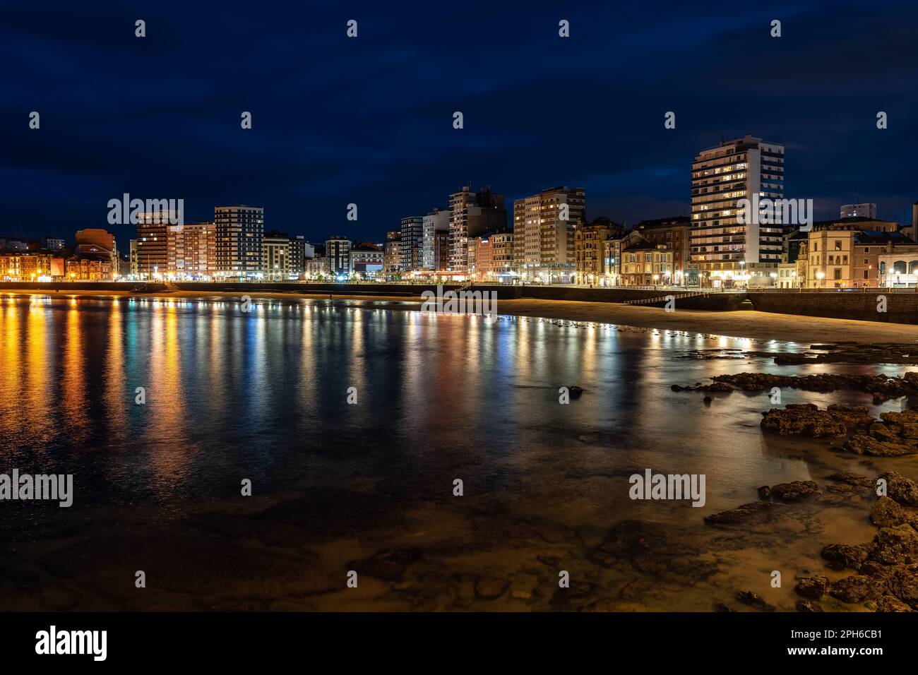 Promenade at night with reflections of lights and buildings in the sea ...