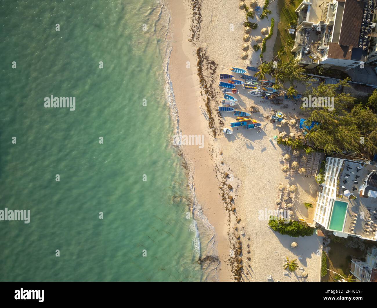 Boats on the beach. Resort. Hotels with swimming pools among palm trees ...