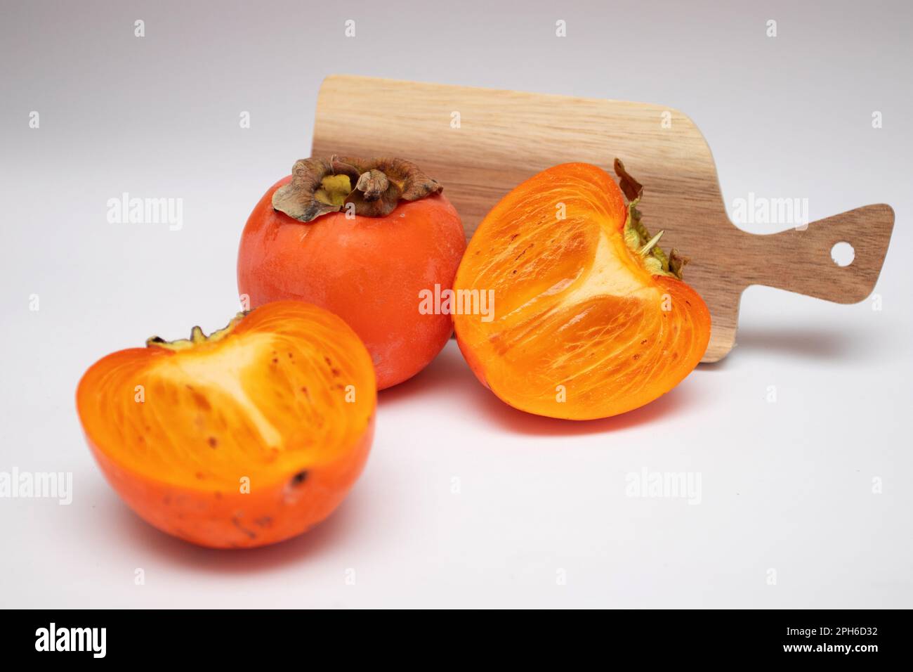 Fresh persimmons and half of persimmons on white background Stock Photo ...