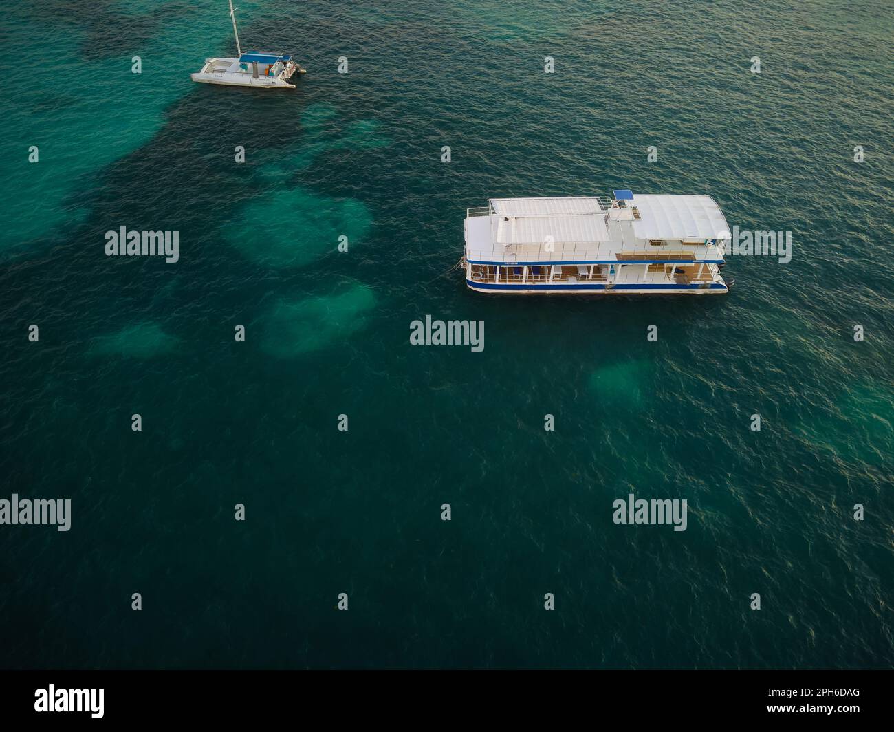 Pleasure boat in emerald sea water. A boat is visible in the distance ...