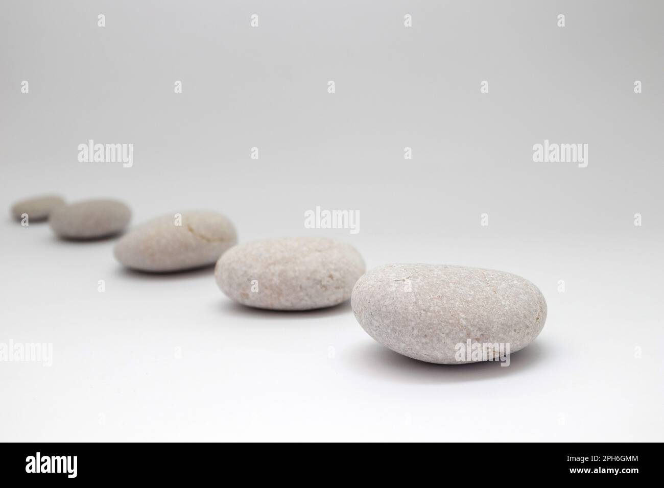 Row of smooth pebbles on white background Stock Photo - Alamy